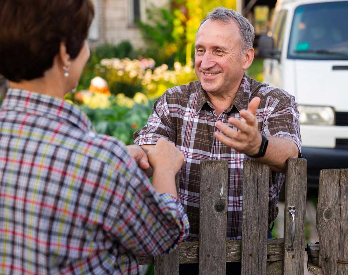 Man and woman chatting across a fence